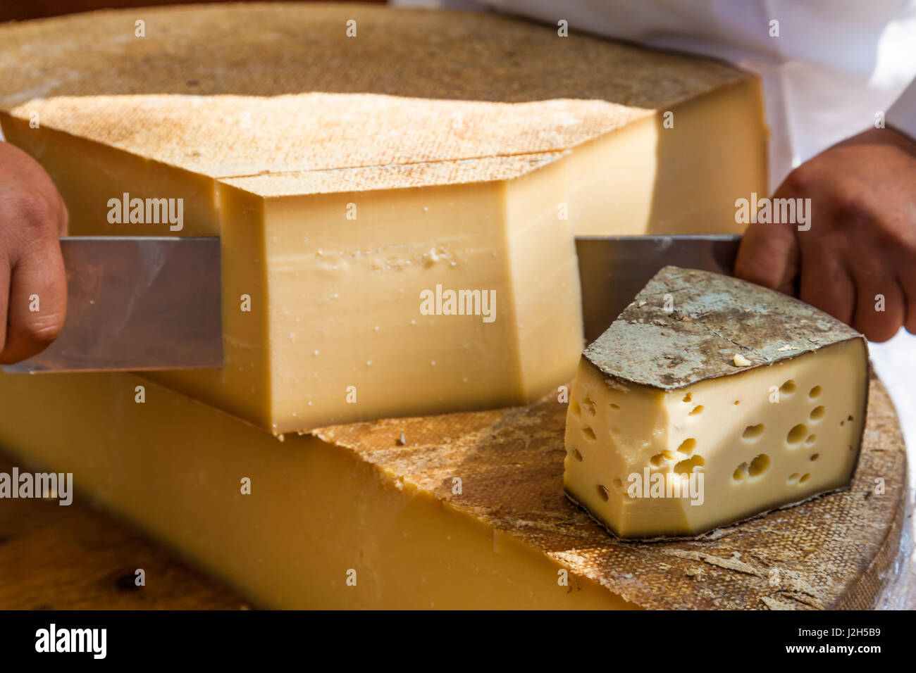 Man cutting piece of cheese Stock Photo - Alamy