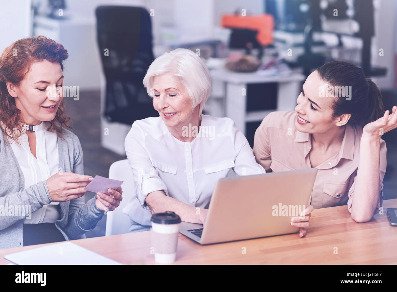 Attractive old office worker turning her head to colleague Stock Photo ...
