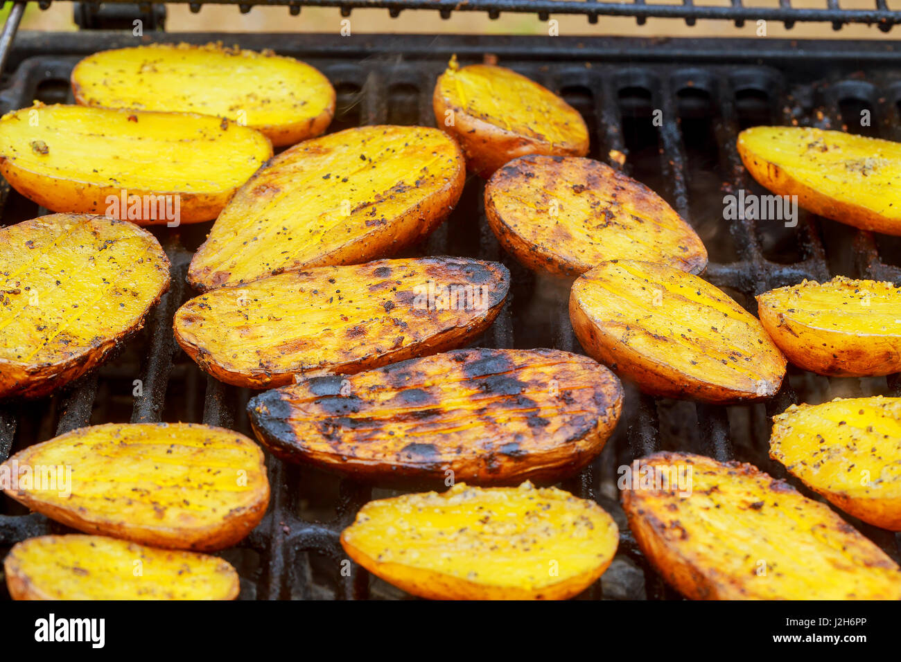 Big Slice Of Village-Style Potatoes On Hot BBQ Charcoal Grill. Flames ...