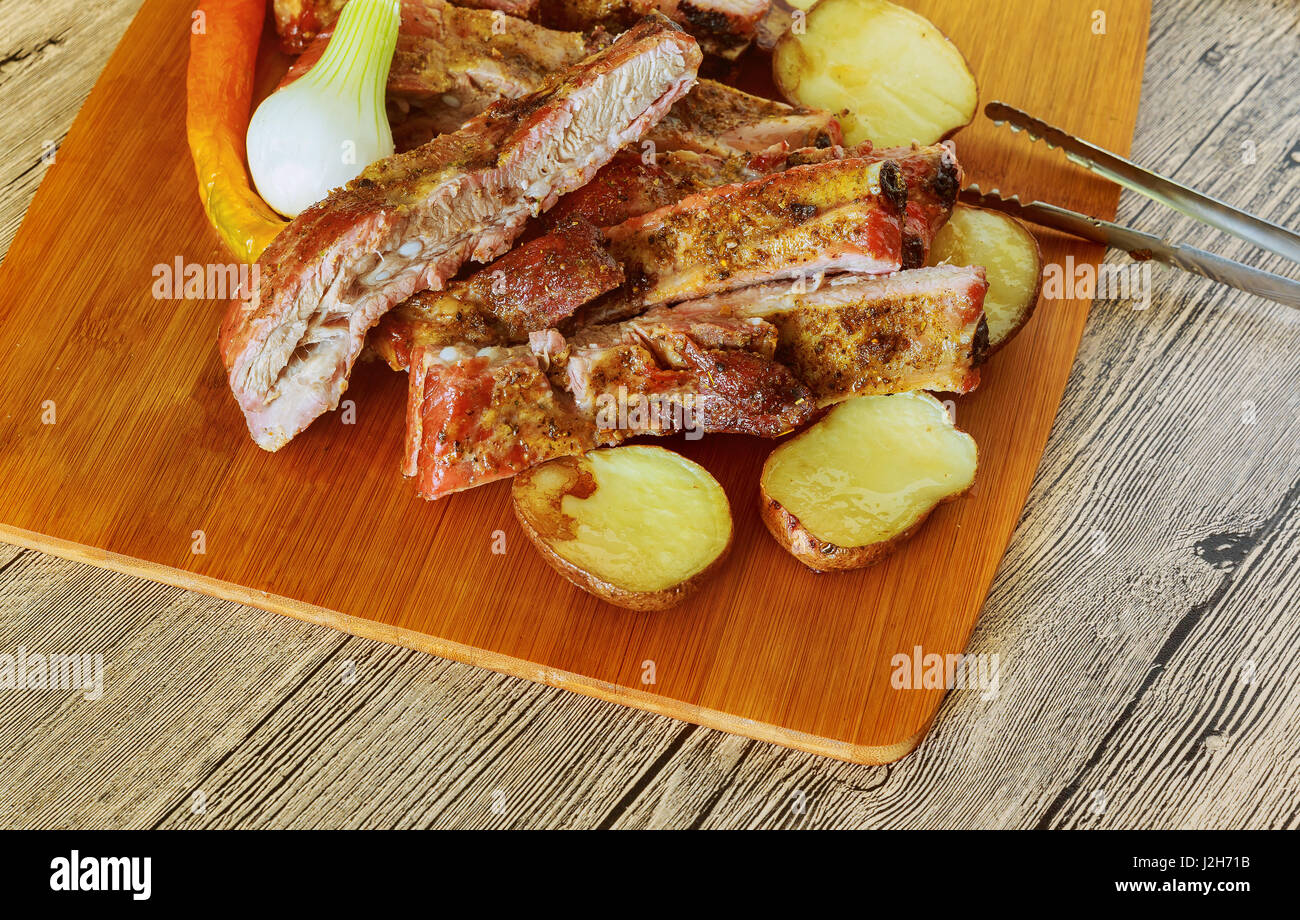 Sliced beef ribs in bbq sauce and baked potatoes,selective focus Stock ...