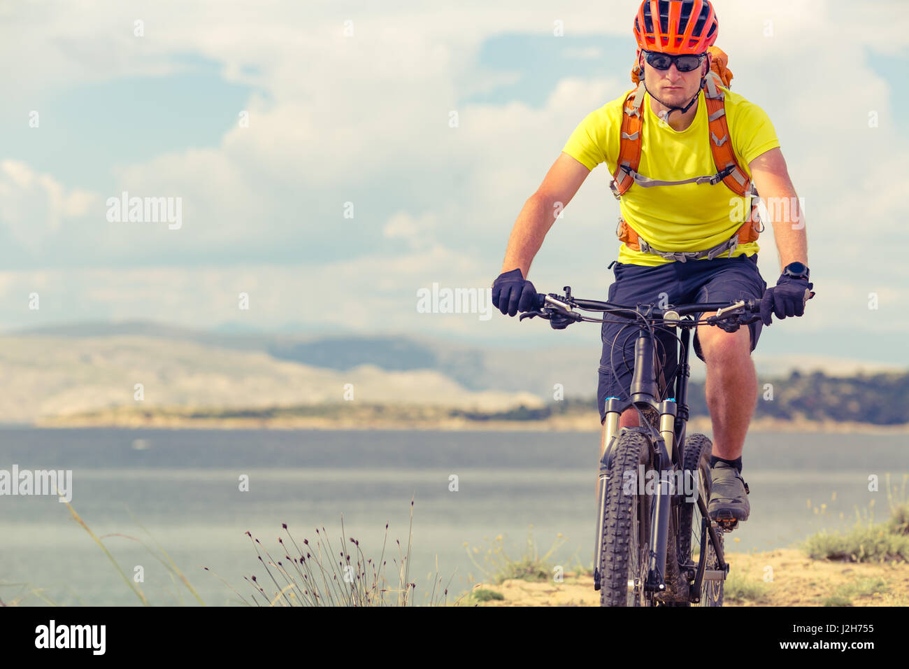 Mountain biker riding on bike at the sea and summer mountains. Man ...