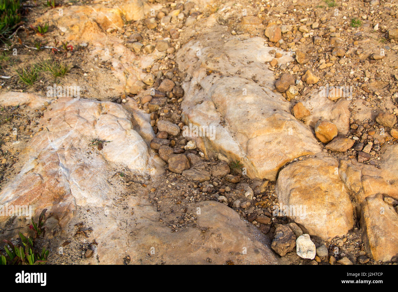 small rock formation in brown tones with lose rocks Stock Photo - Alamy