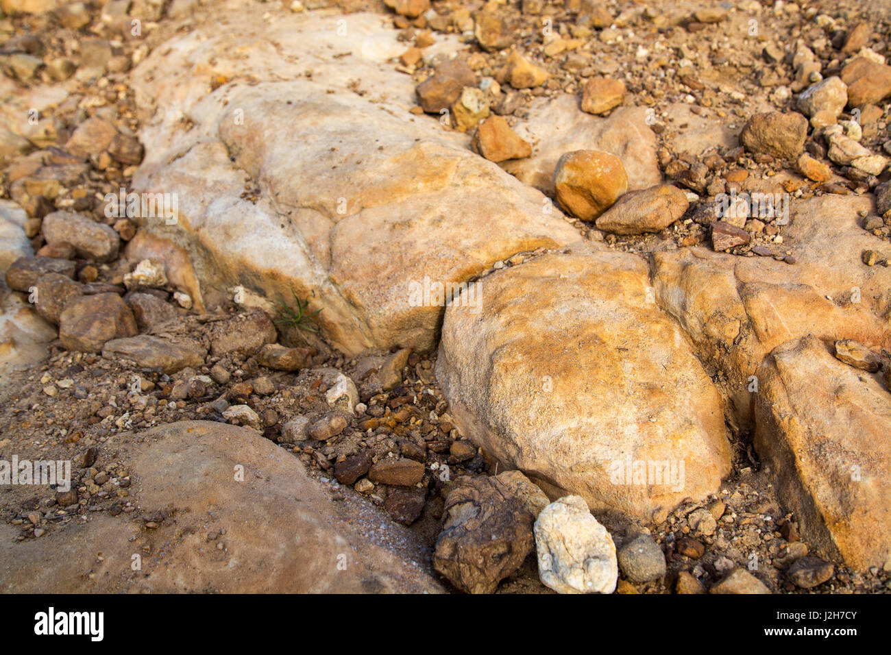 small rock formation in brown tones with lose rocks Stock Photo - Alamy