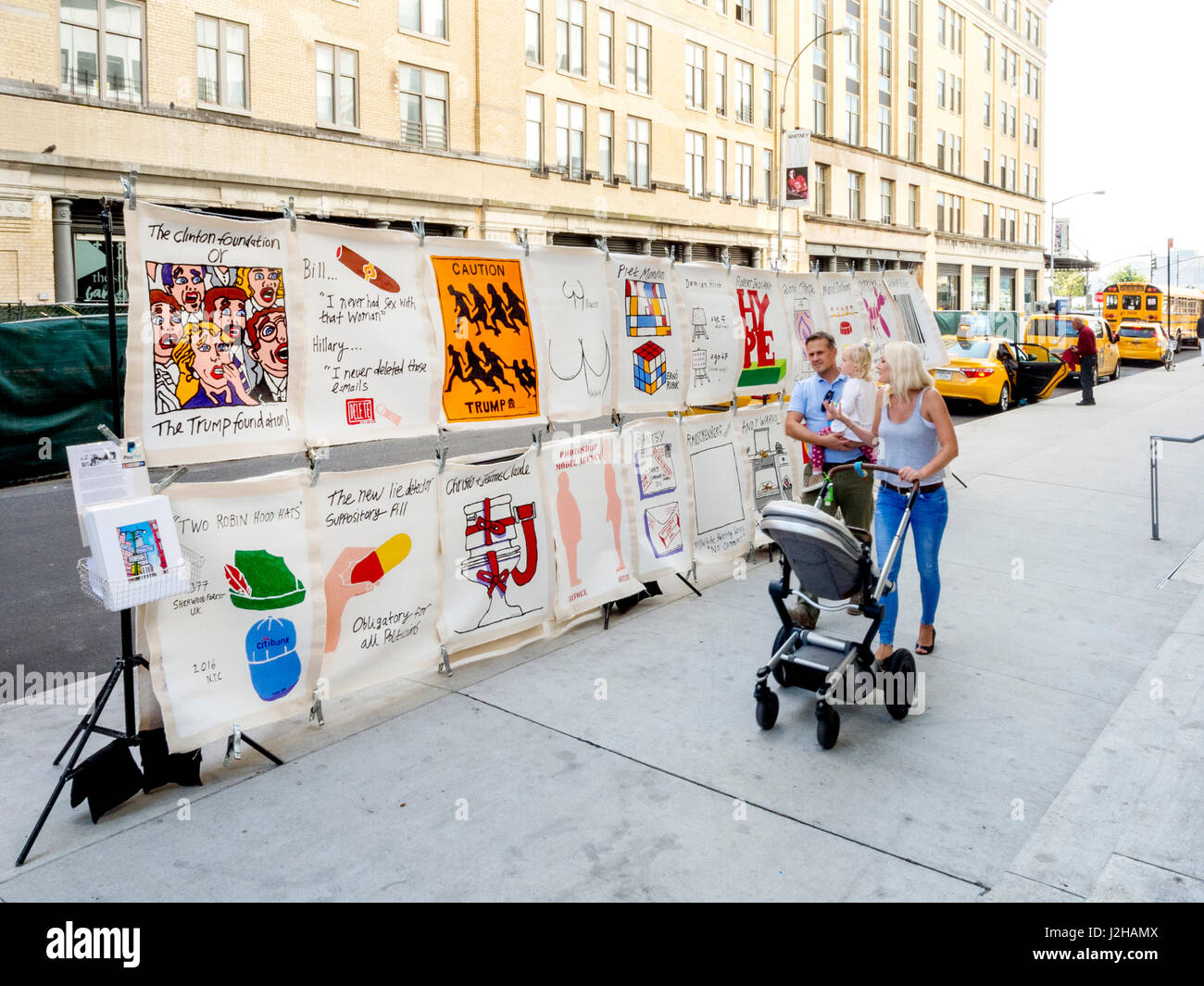 A sidewalk display of prints by artist Tiggy Ticehurst are viewed by a ...