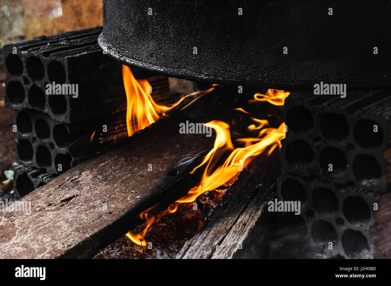 Large black cooking pot on a rustic stove improvised on the floor ...