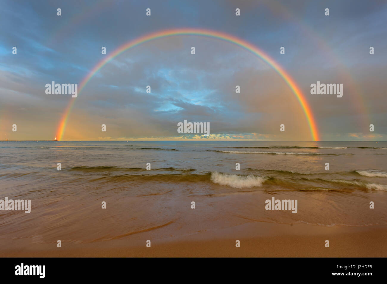 Full arcing rainbow over Lake Michigan and Ludington lighthouse in ...