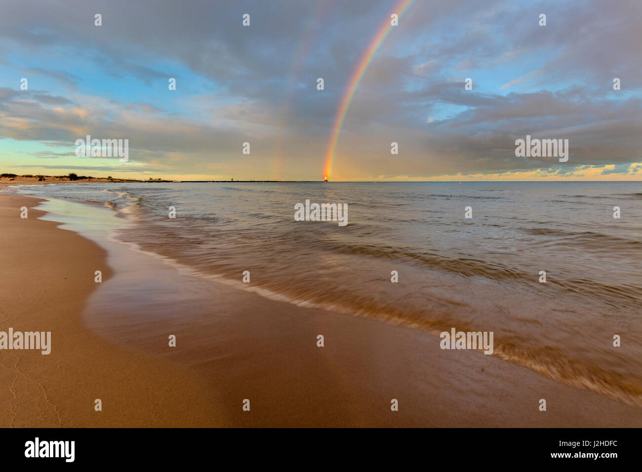 Full arcing rainbow over Lake Michigan and Ludington lighthouse in ...