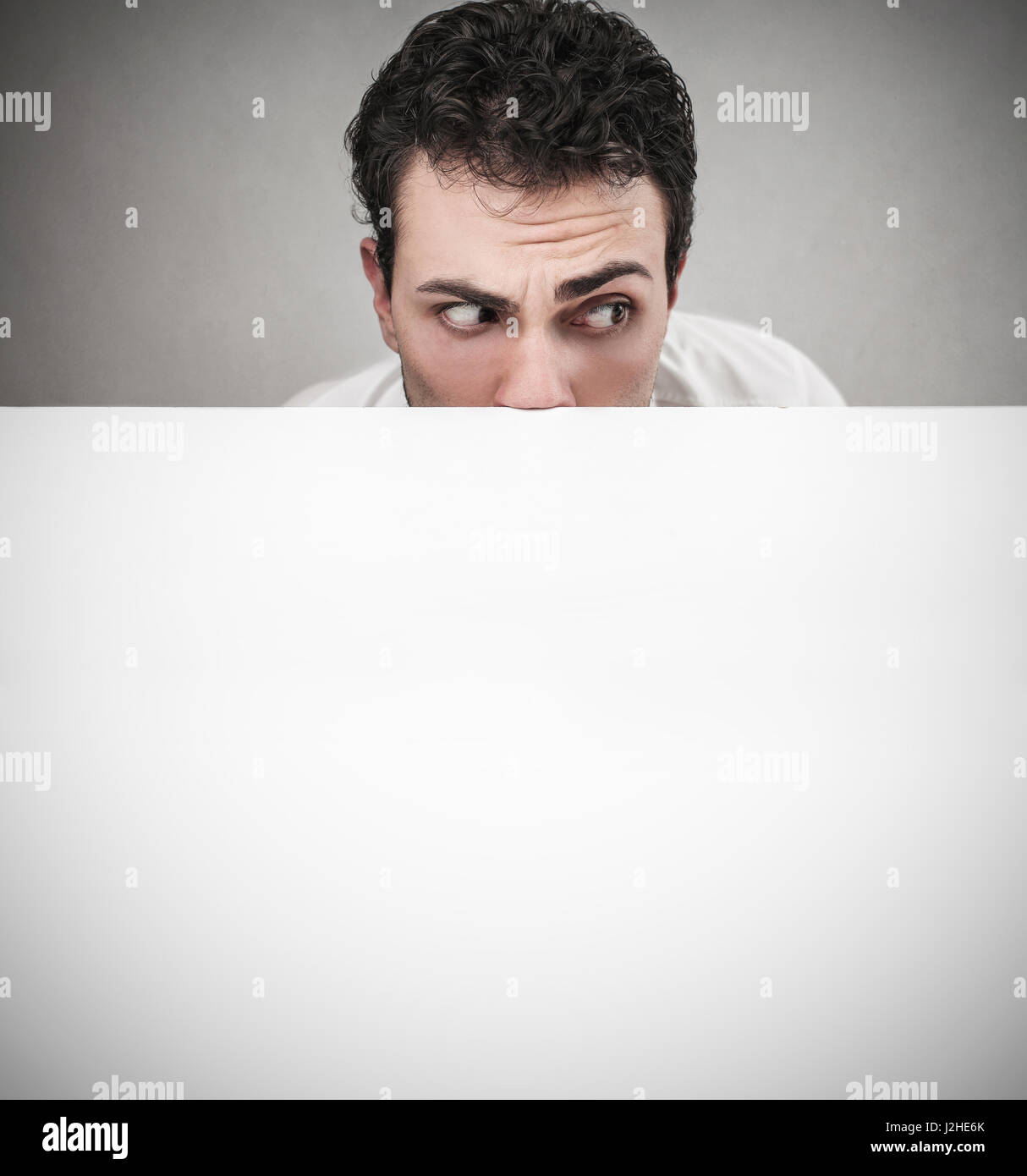 Man hiding behind white paper Stock Photo - Alamy