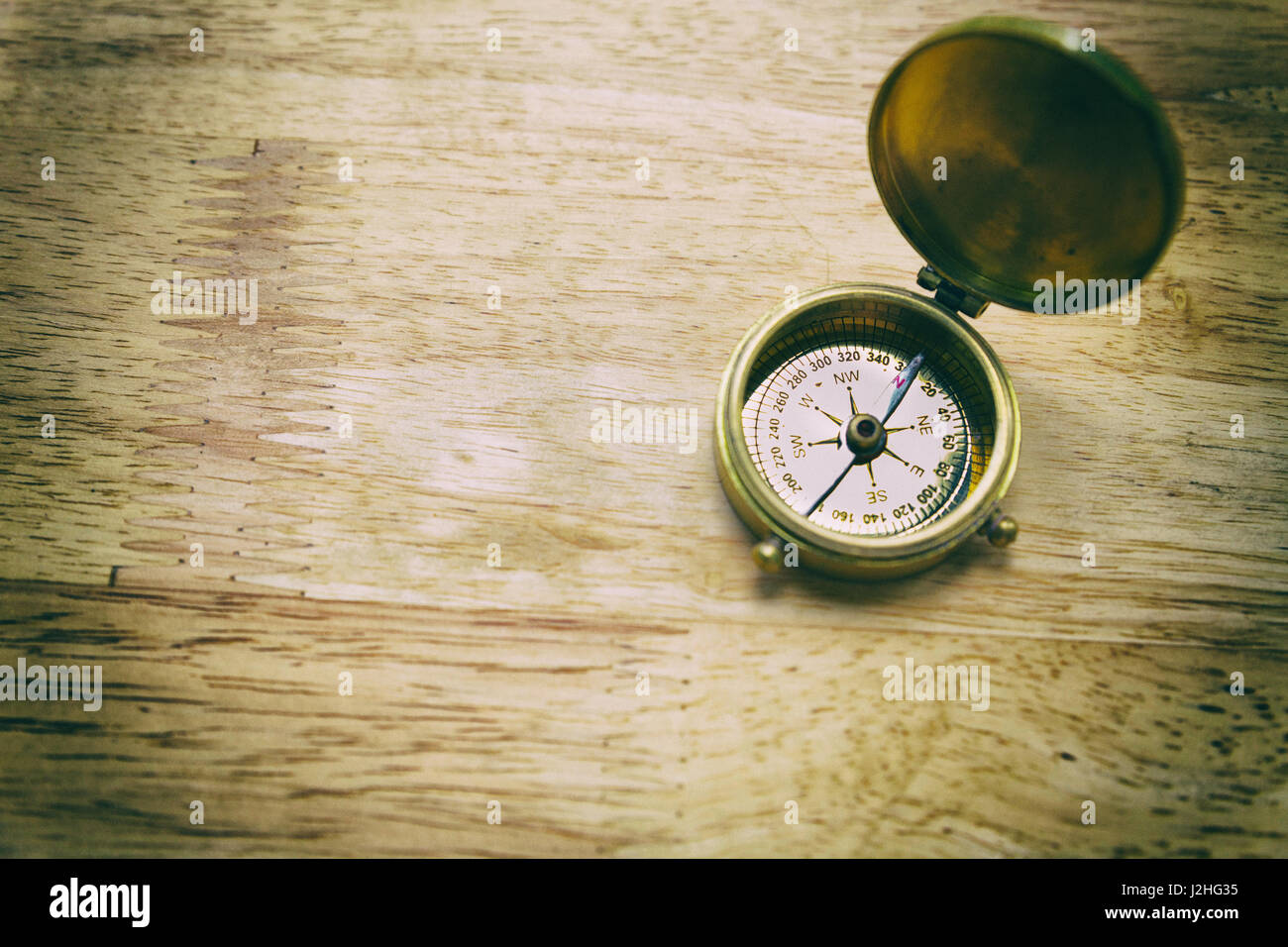 Antique retro golden compass on wood table. concept for direction ...