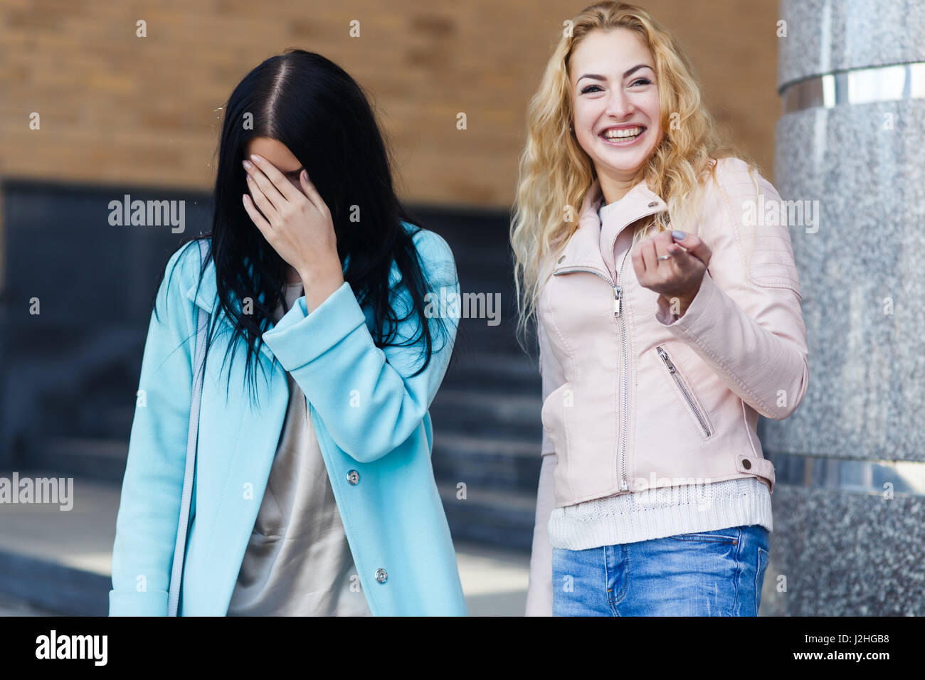 Two happy girls near building in spring Stock Photo - Alamy