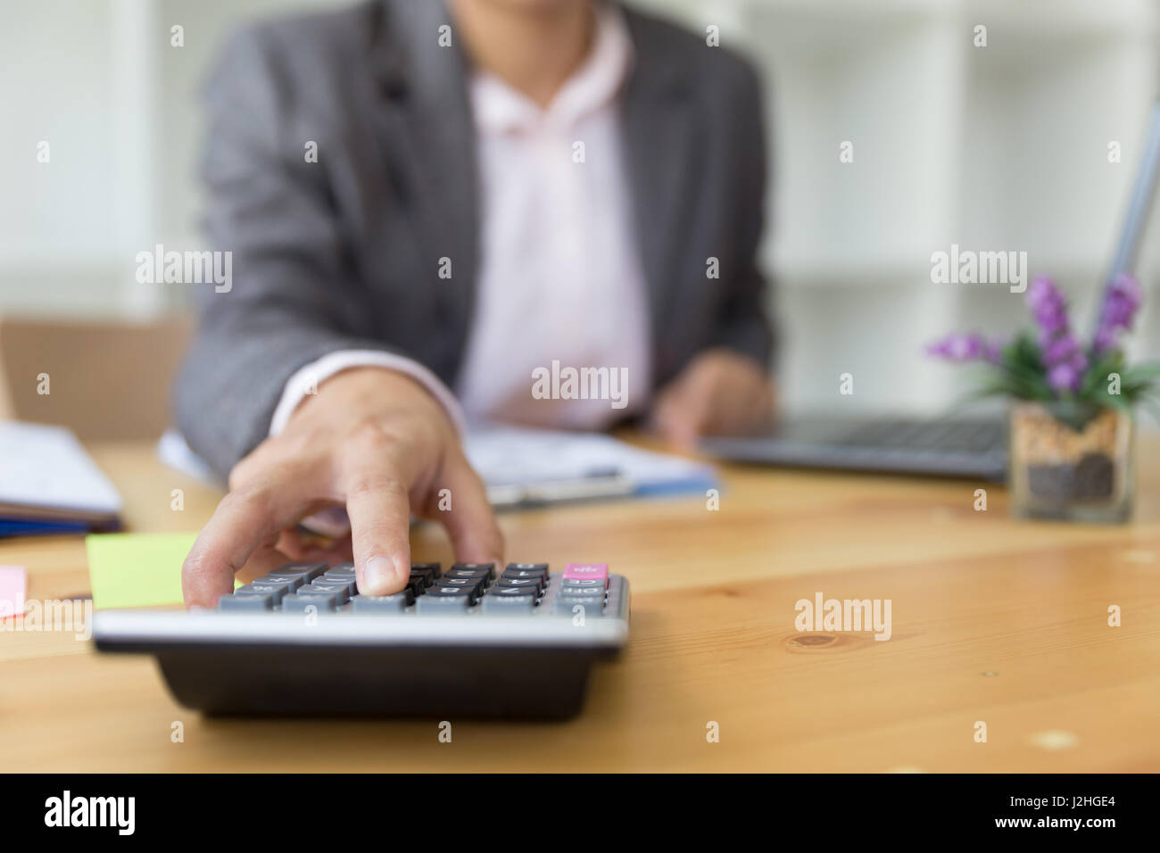 Businesswoman using a calculator to calculate the numbers. Accounting ...