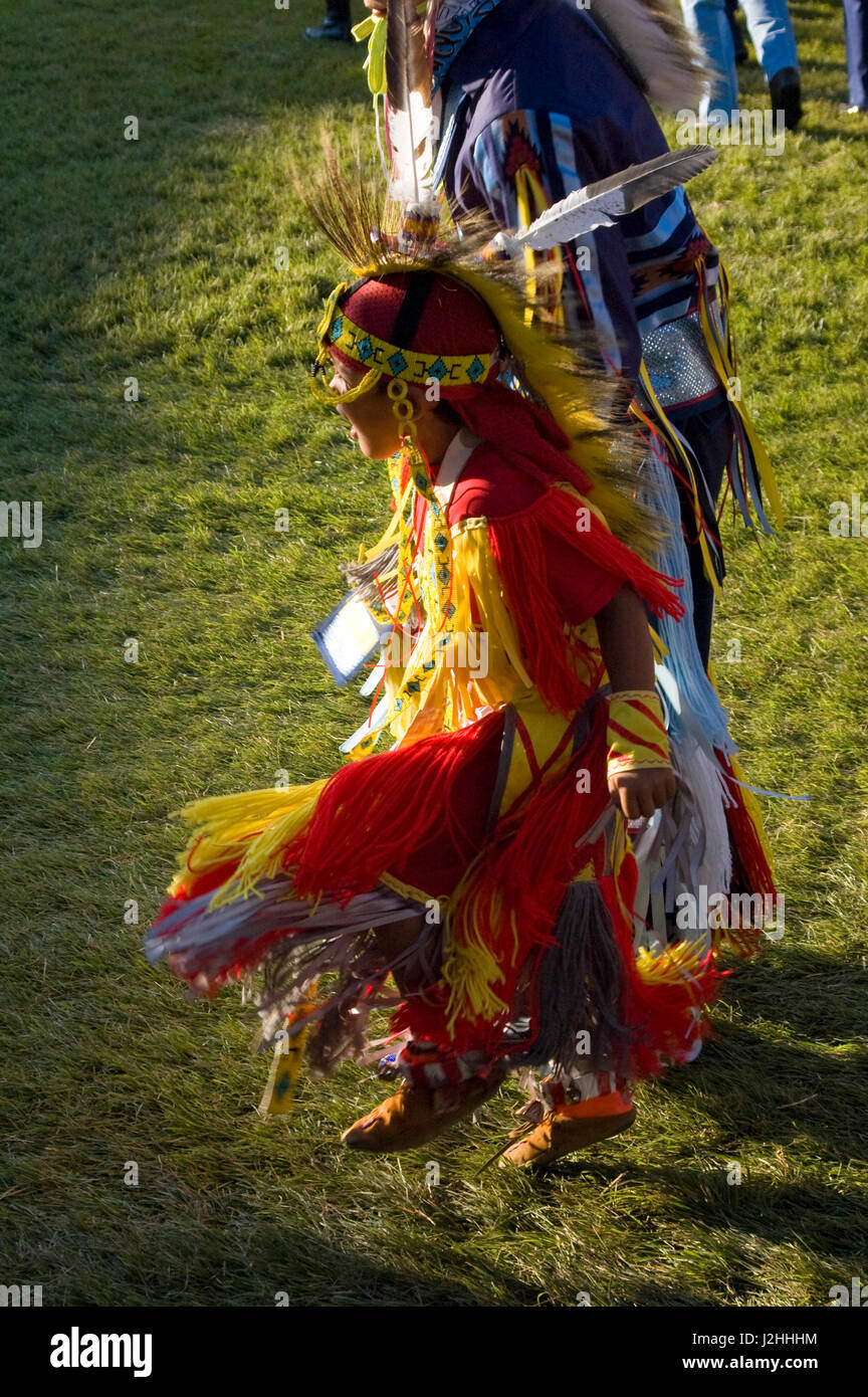 Traditional boys grass dancer dressed in regalia participates during a ...