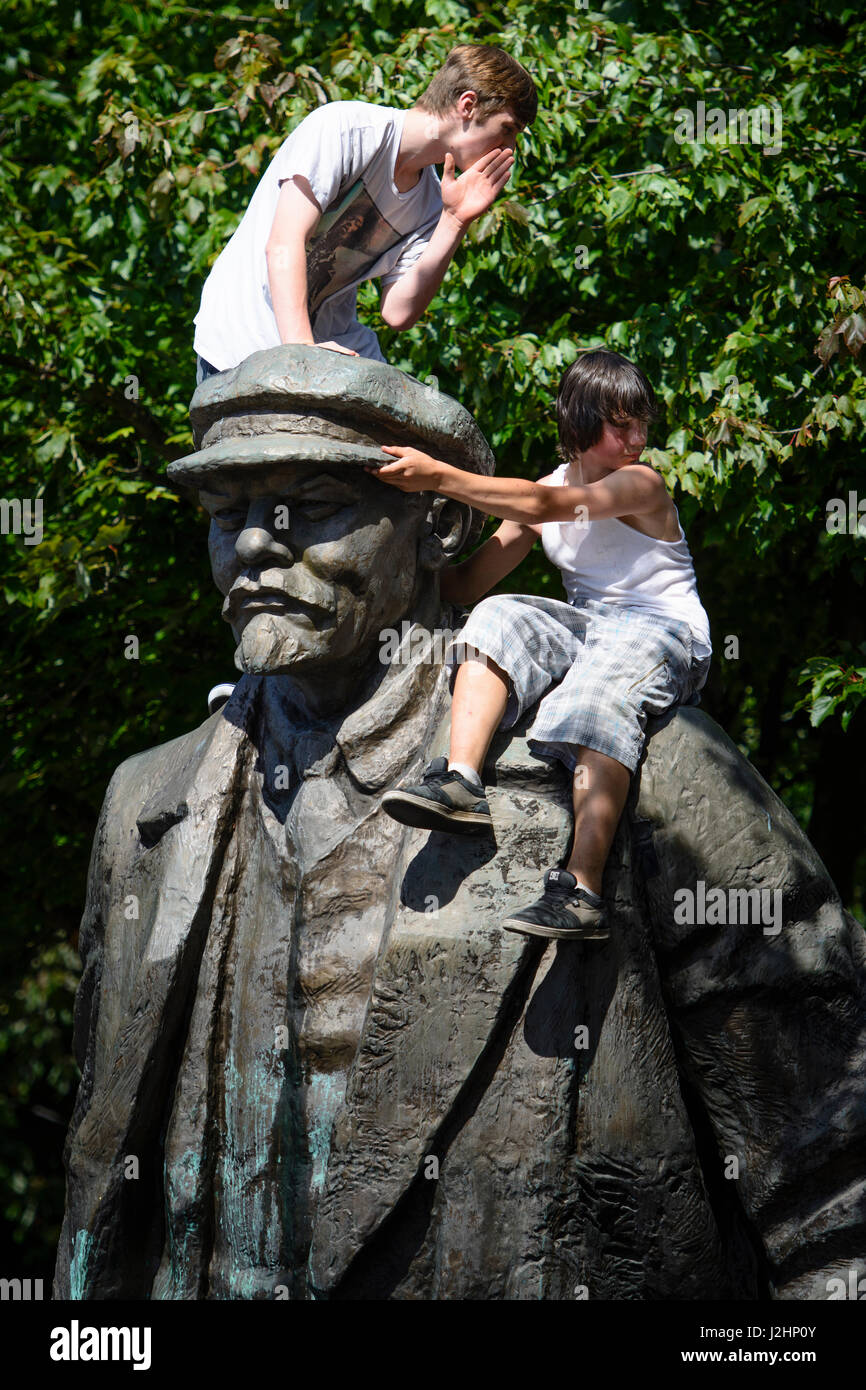 Seattle, Washington. Two boys climbing statue of Lenin at Fremont ...