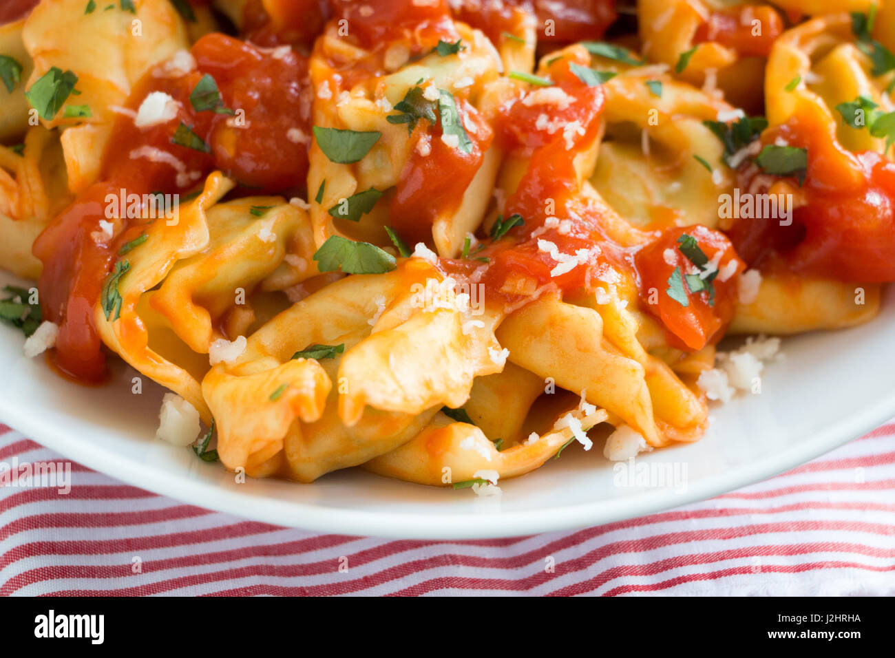 Fresh tortellini with homemade tomato sauce, chopped herbs and parmesan ...