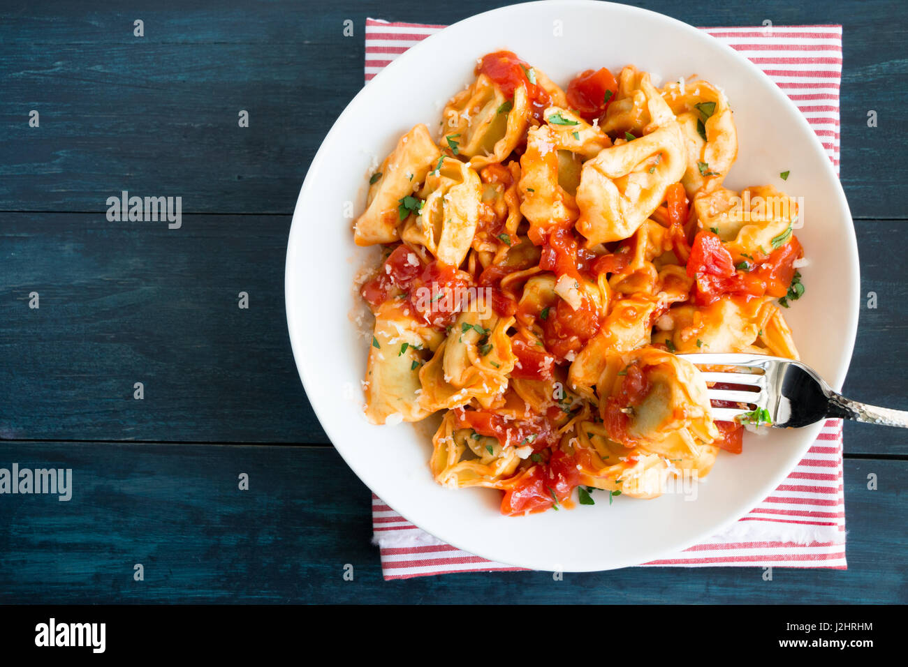 Fresh tortellini with homemade tomato sauce, chopped herbs and parmesan ...