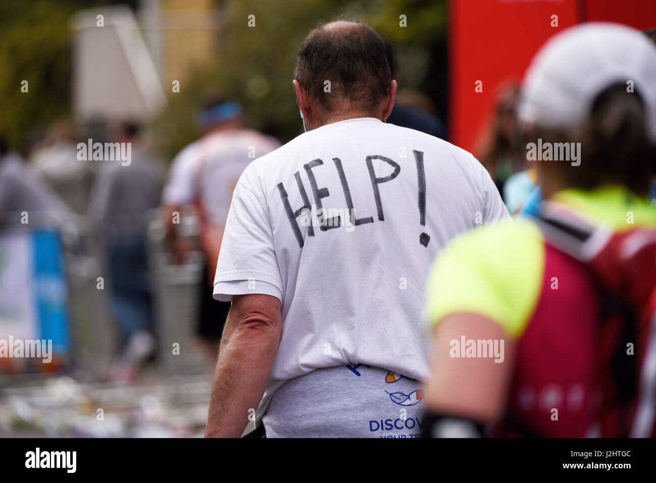 A fun runner with HELP ! written on the back of his shirt taking part ...