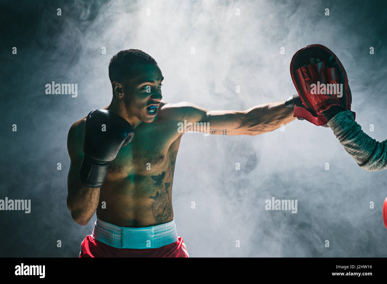 Afro american male boxer. Young man boxing workout in a fitness club ...