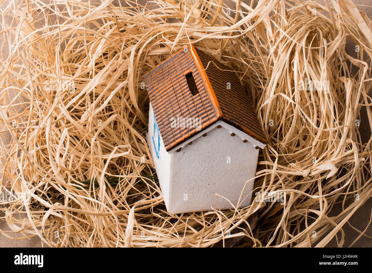 Little model house places on a straw background Stock Photo - Alamy