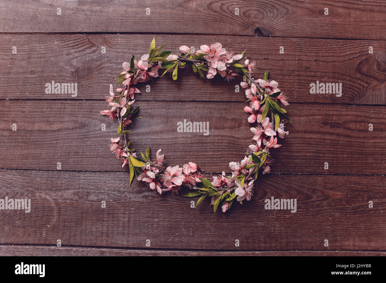 Wreath of peach tree flowers on a wooden table background, photo in ...