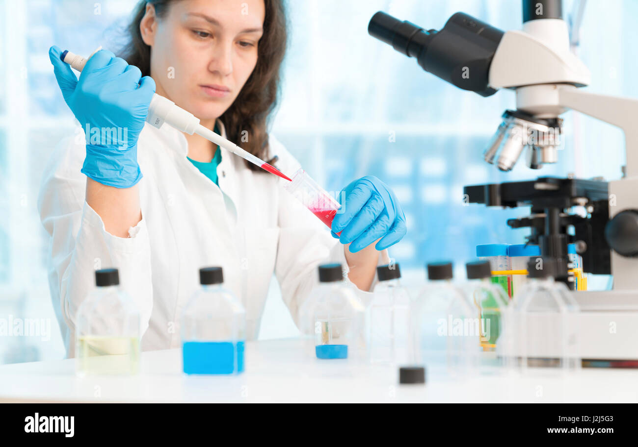 Female scientist holding test tube and using pipette Stock Photo - Alamy