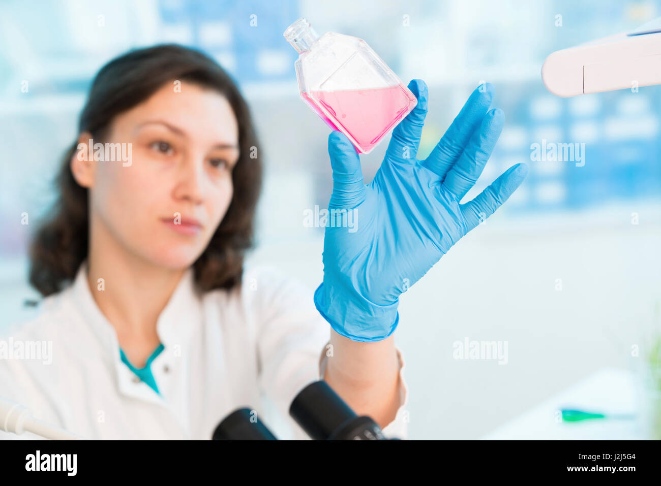 Female scientist holding sample in glass bottle Stock Photo - Alamy