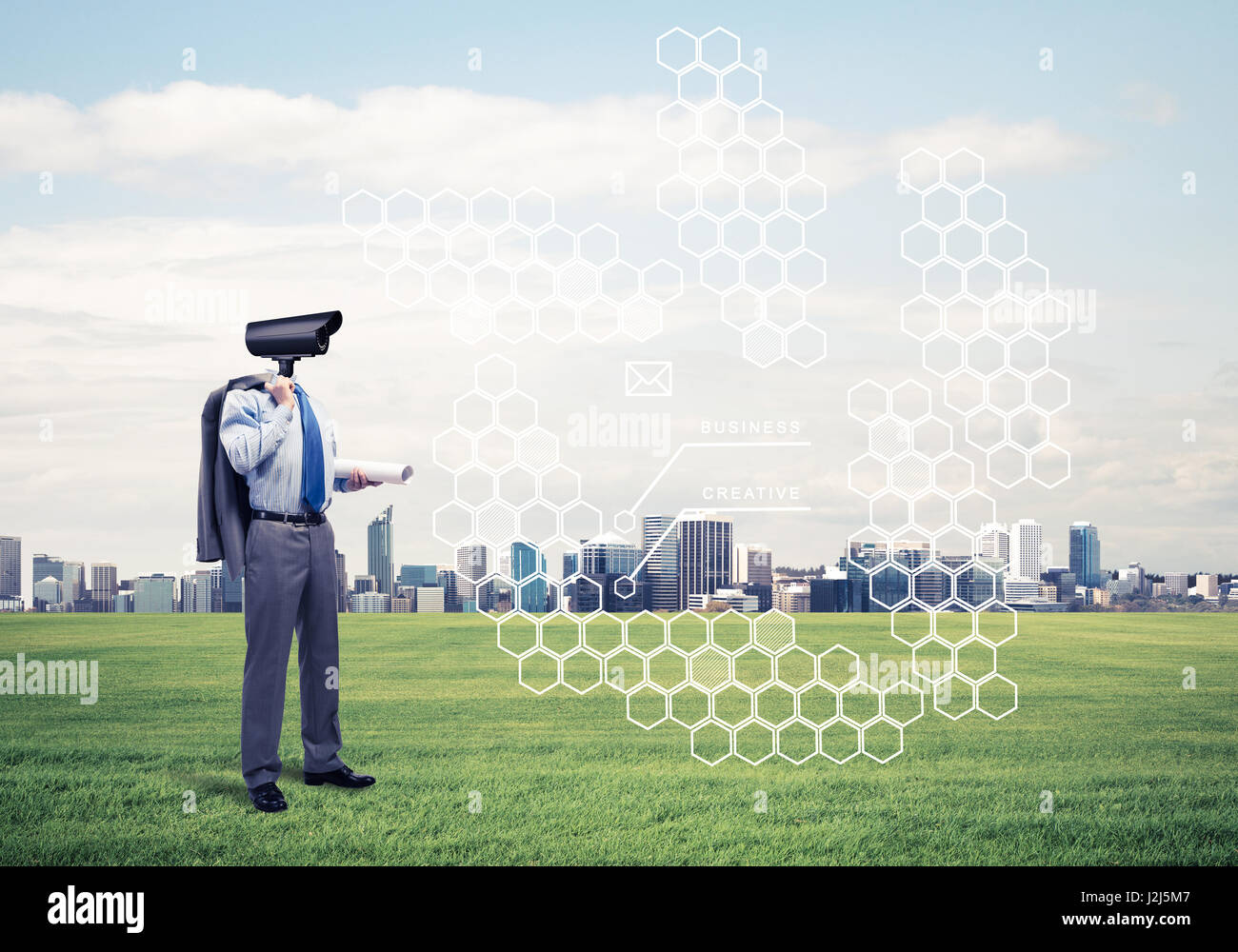 Camera headed man standing on green grass against modern citysca Stock ...
