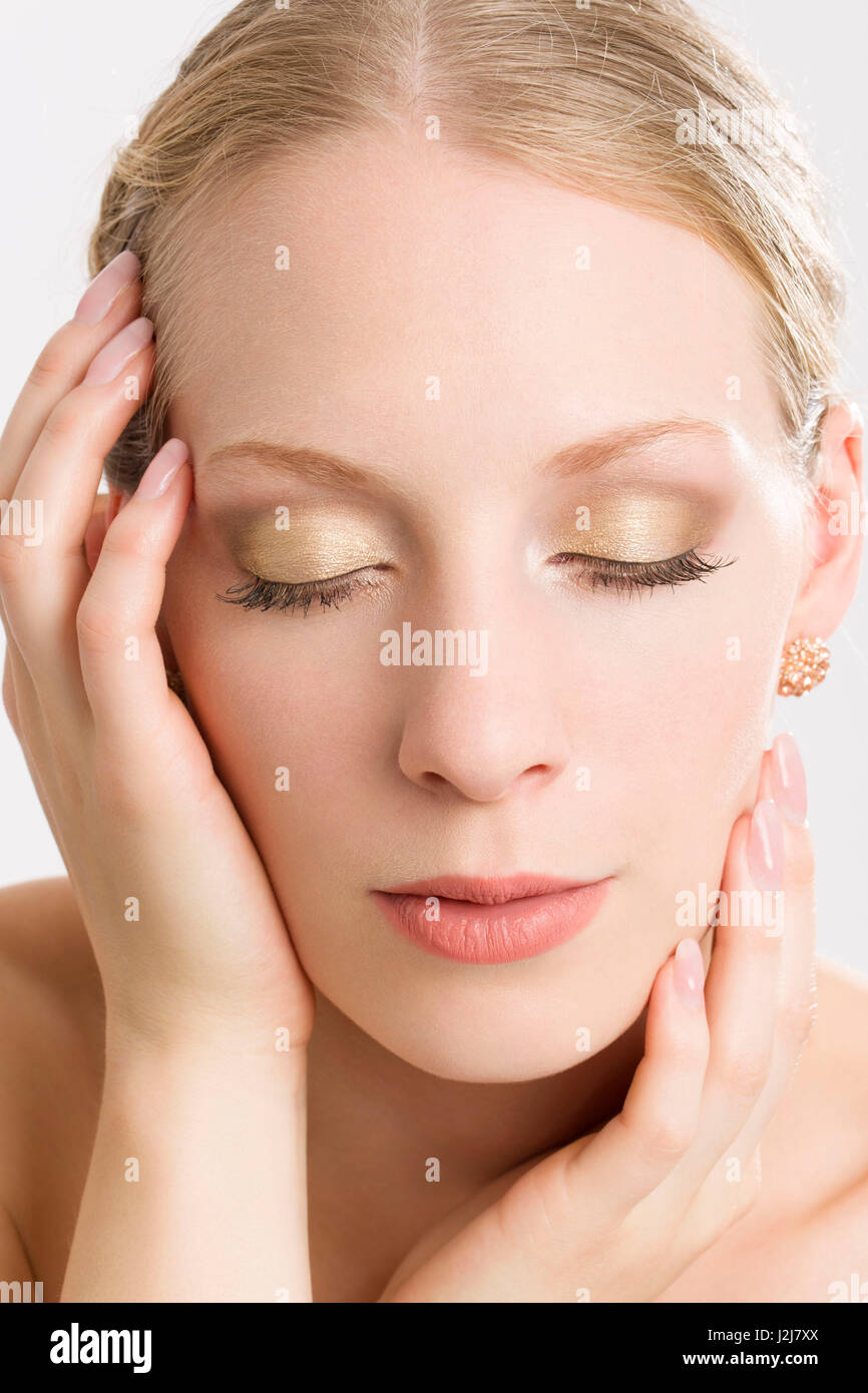 young woman, bride, bridal make-up, hands in the face, eyes closed ...