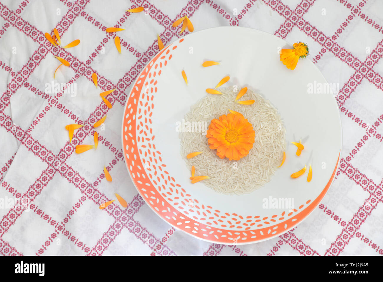 Marigold on coloured plate with rice Stock Photo - Alamy