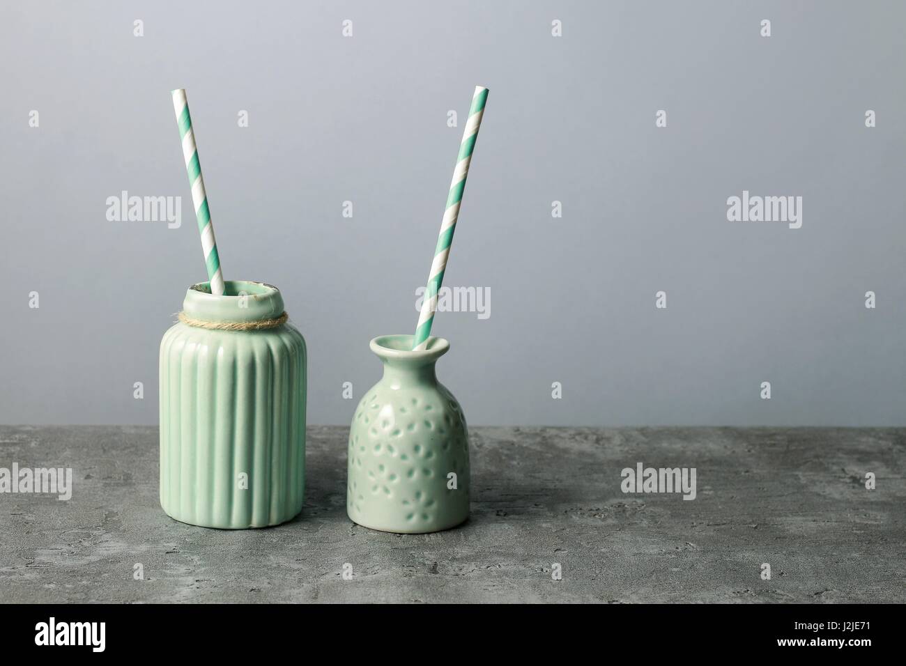 Ceramic jars and stripped straws. Party time Stock Photo - Alamy