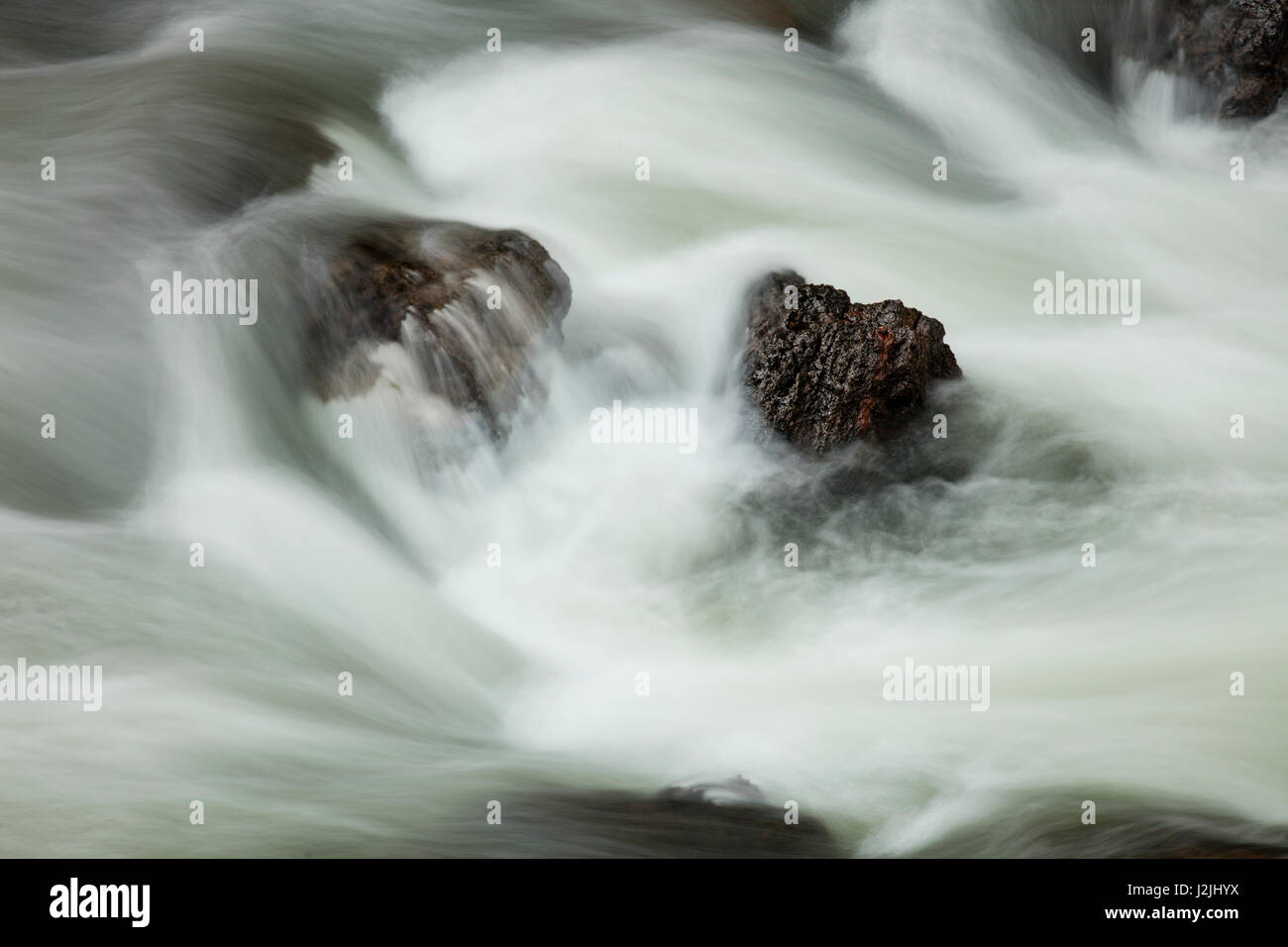 Water flowing around rocks, Firehole River, Yellowstone National Park ...