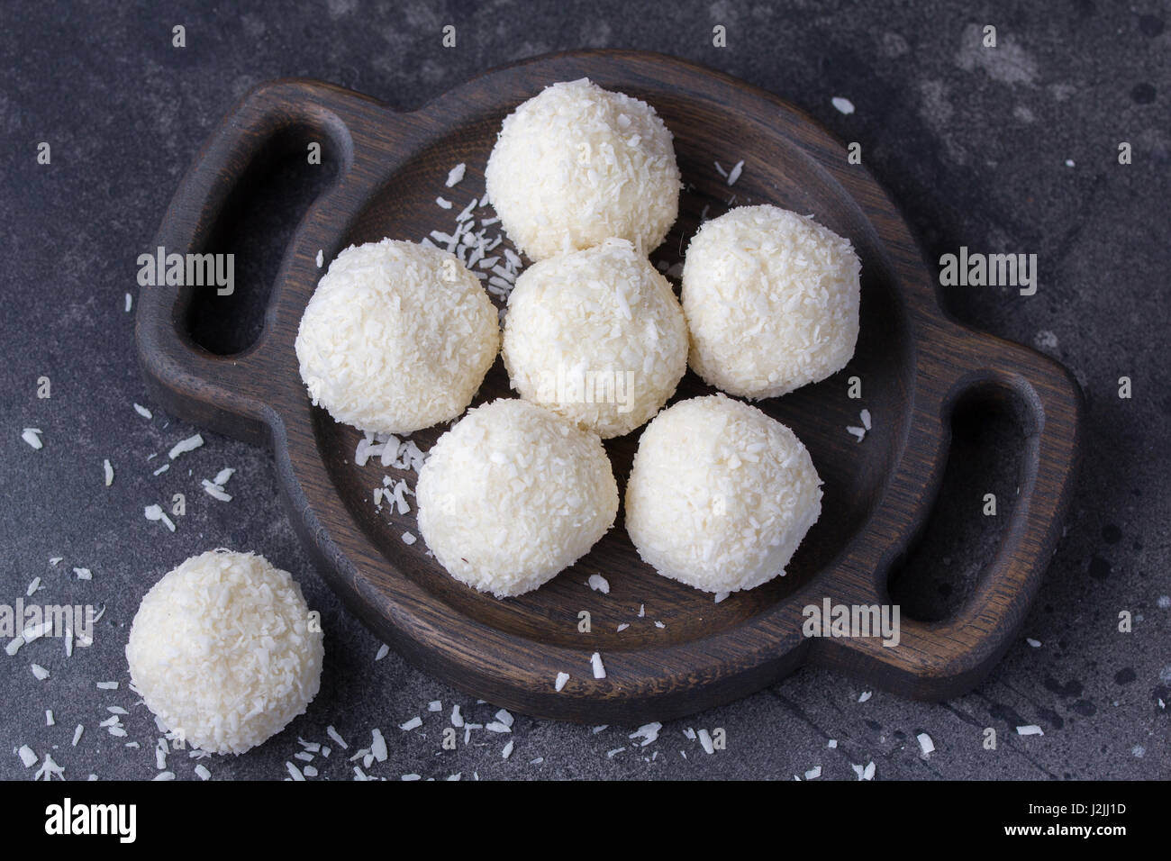 Coconut candy on a wooden black board. Round coconut balls Stock Photo ...