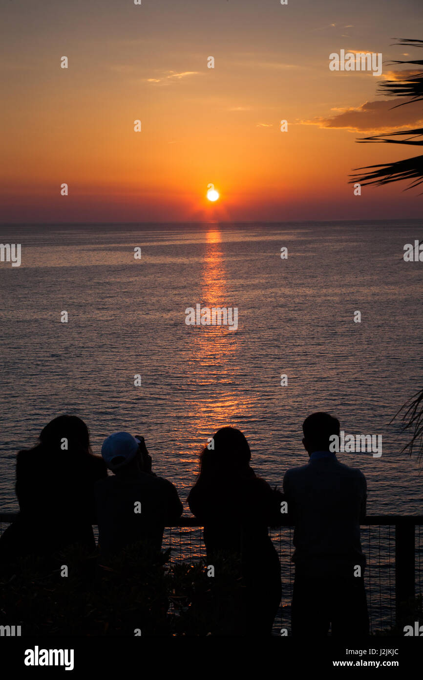 silhouette of people watching beautiful sunset by the sea Stock Photo ...
