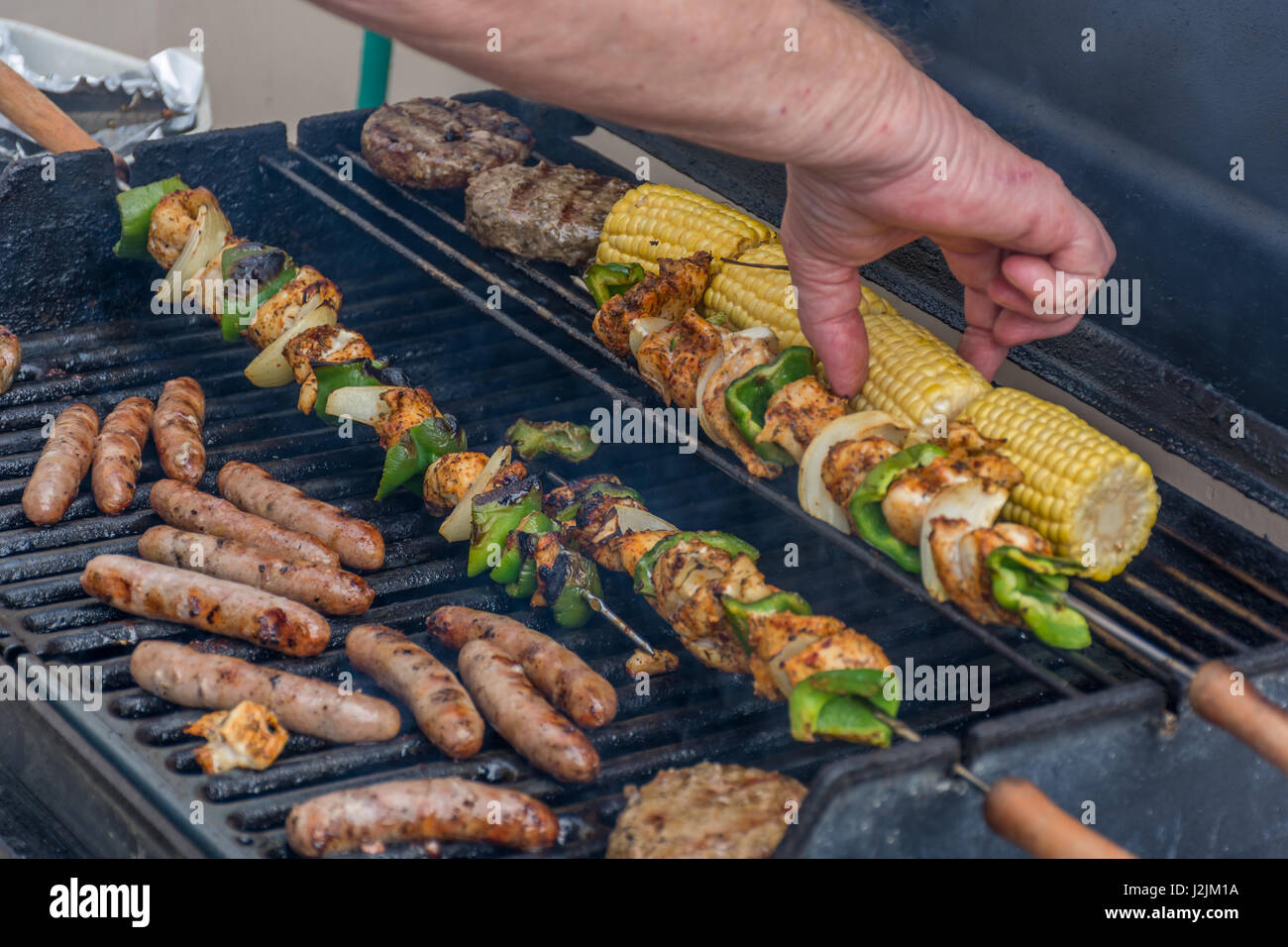 Male hand cooking on a gas grill in England UK Stock Photo - Alamy