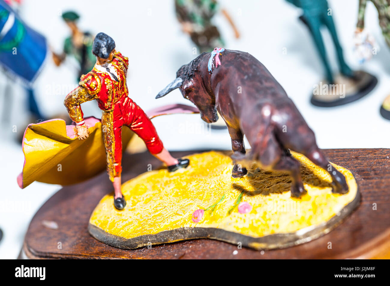 Tiny miniature vintage spanish bullfighter with bull figurine standing ...