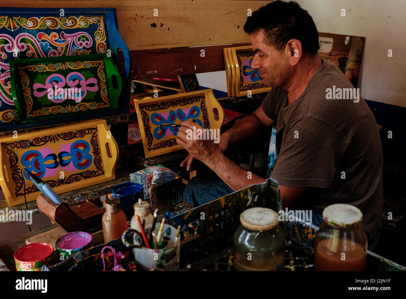 A painter decorates trays with traditional Costa Rican designs at the ...