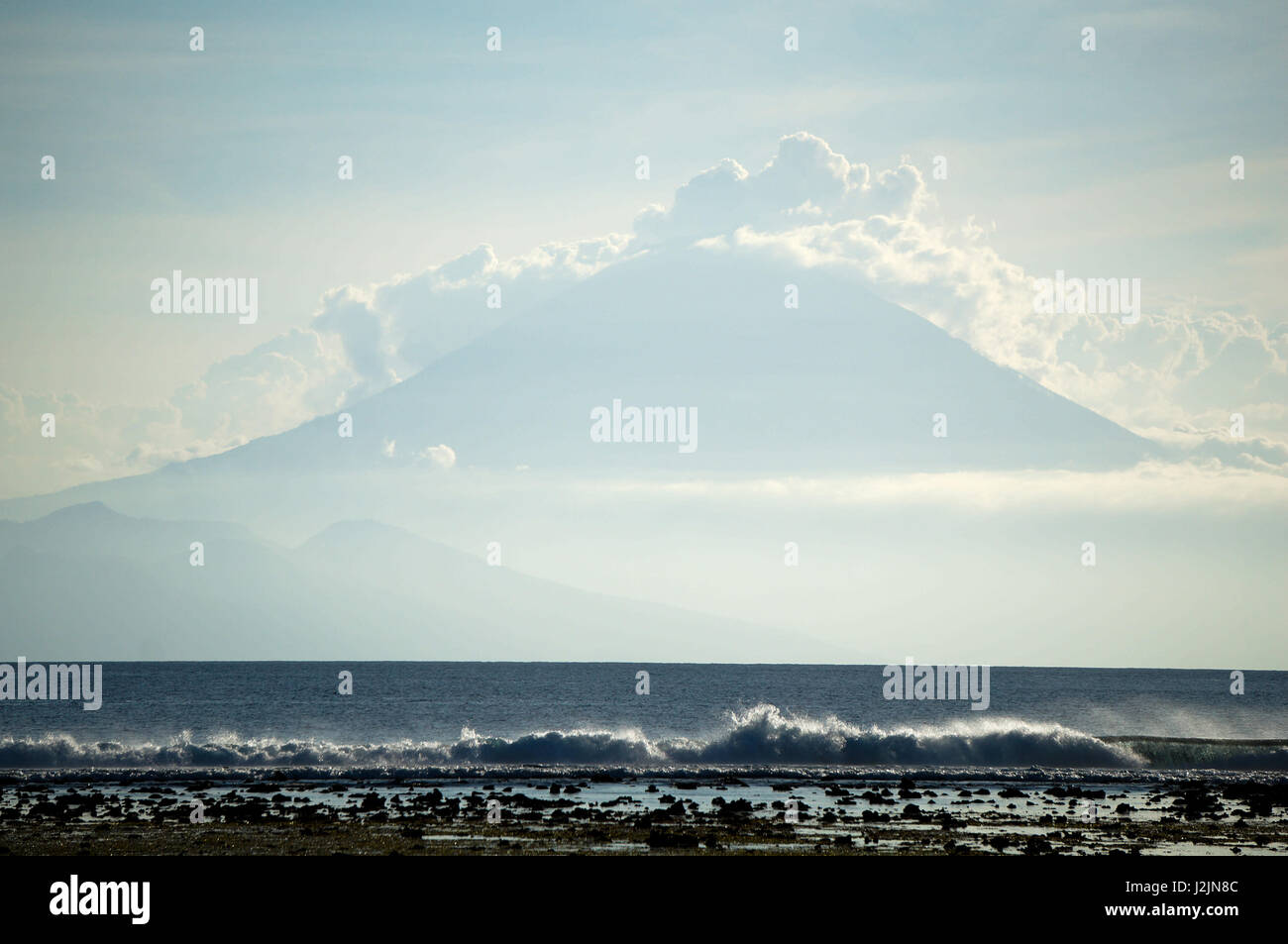 A view of a cloud-covered volcano in the distance Stock Photo - Alamy