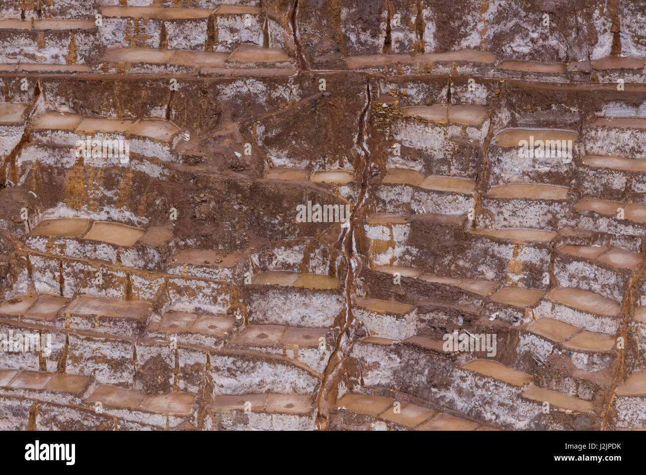 The hot spring water is channeled to fill up the individual salt pans ...
