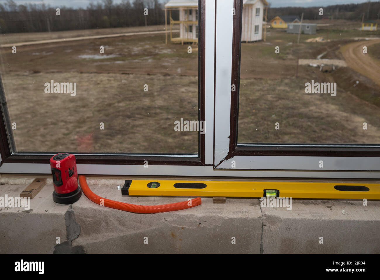 Laser level, installation of windows in a country house Stock Photo - Alamy