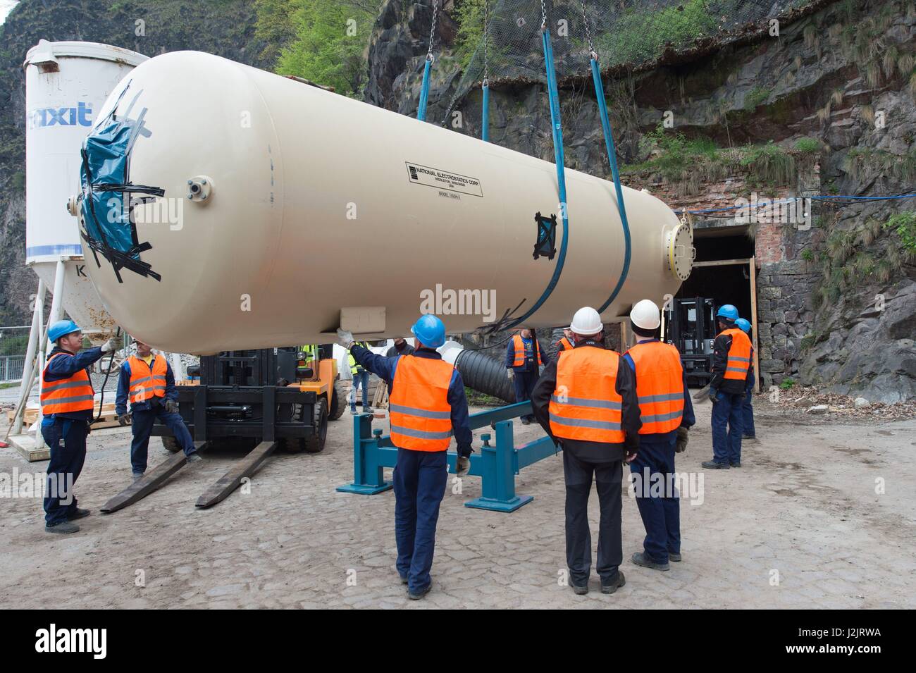 An eight-meter-long and ten-ton particle accelerator tank hanging from ...