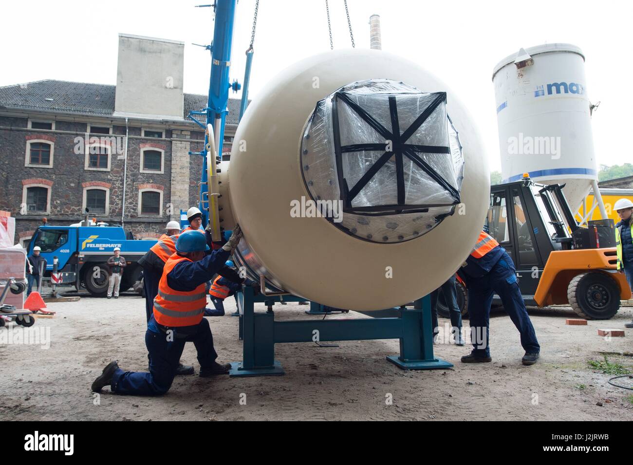 An eight-meter-long and ten-ton particle accelerator tank hanging from ...