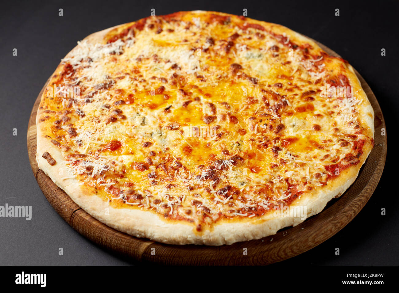 Hot pizza Quattro Formaggi on a rustic wooden table. Italian food Stock Photo - Alamy