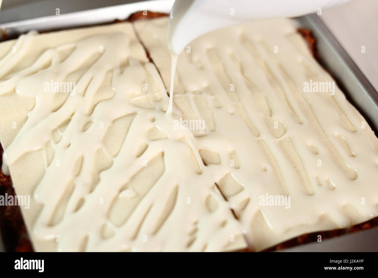 Pouring bechamel sauce onto pasta sheets layer. Making Lasagna ...
