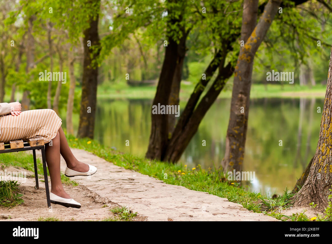 Feet of beautiful young woman sitting on bench in park Stock Photo - Alamy