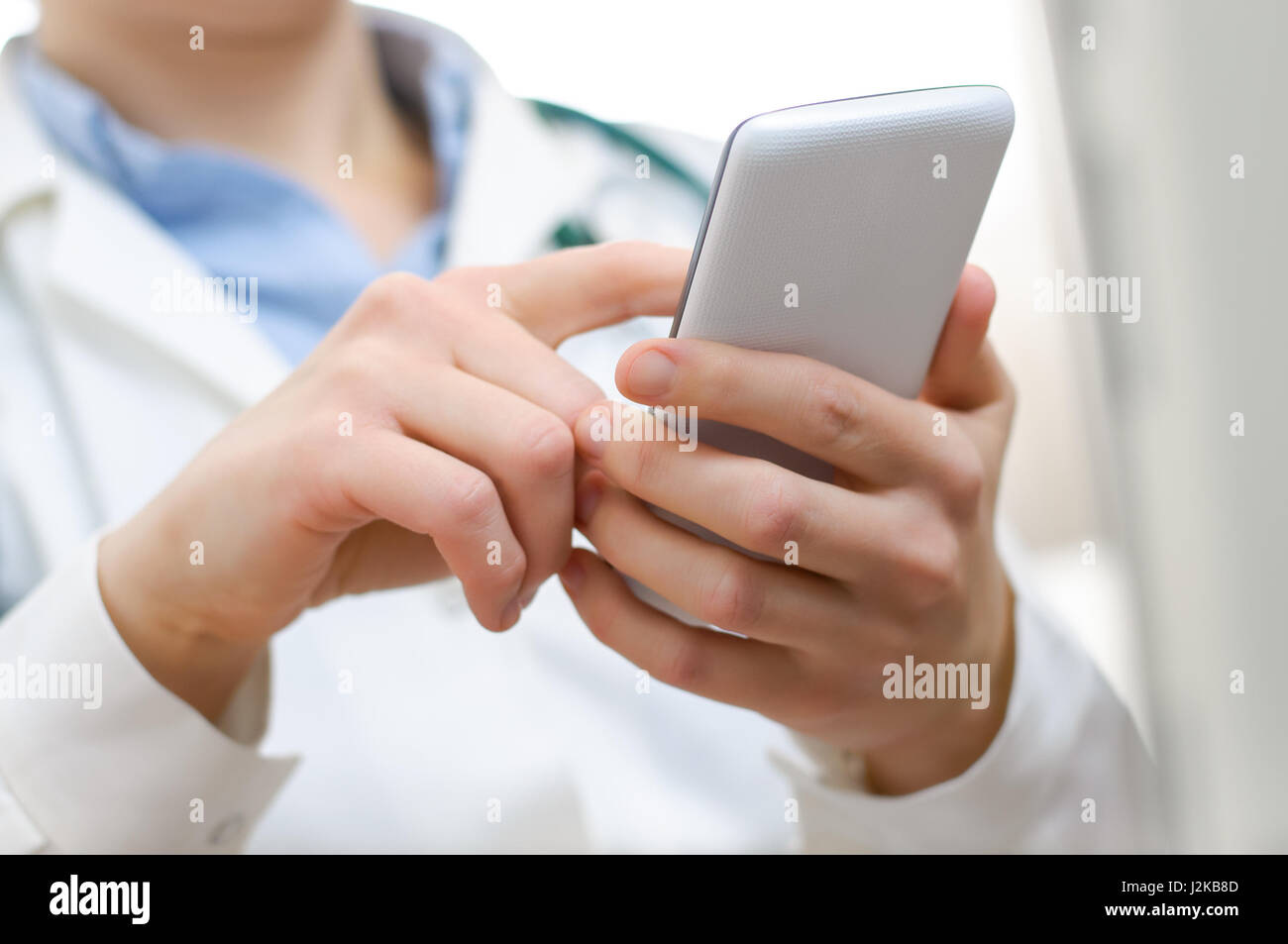 A female doctor texting on smartphone in medical office Stock Photo - Alamy