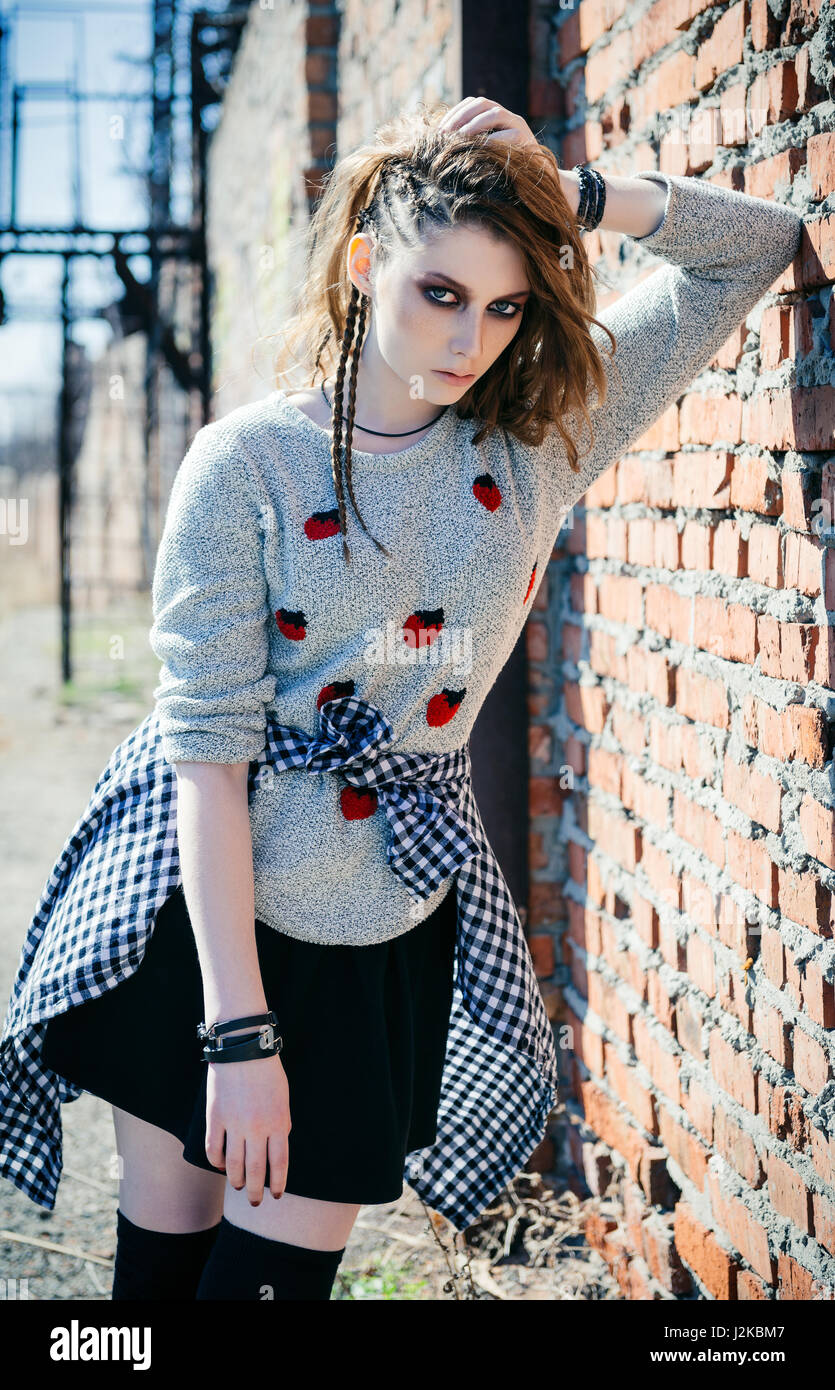Lovely sad grunge (rock) girl standing near the wall Stock Photo - Alamy