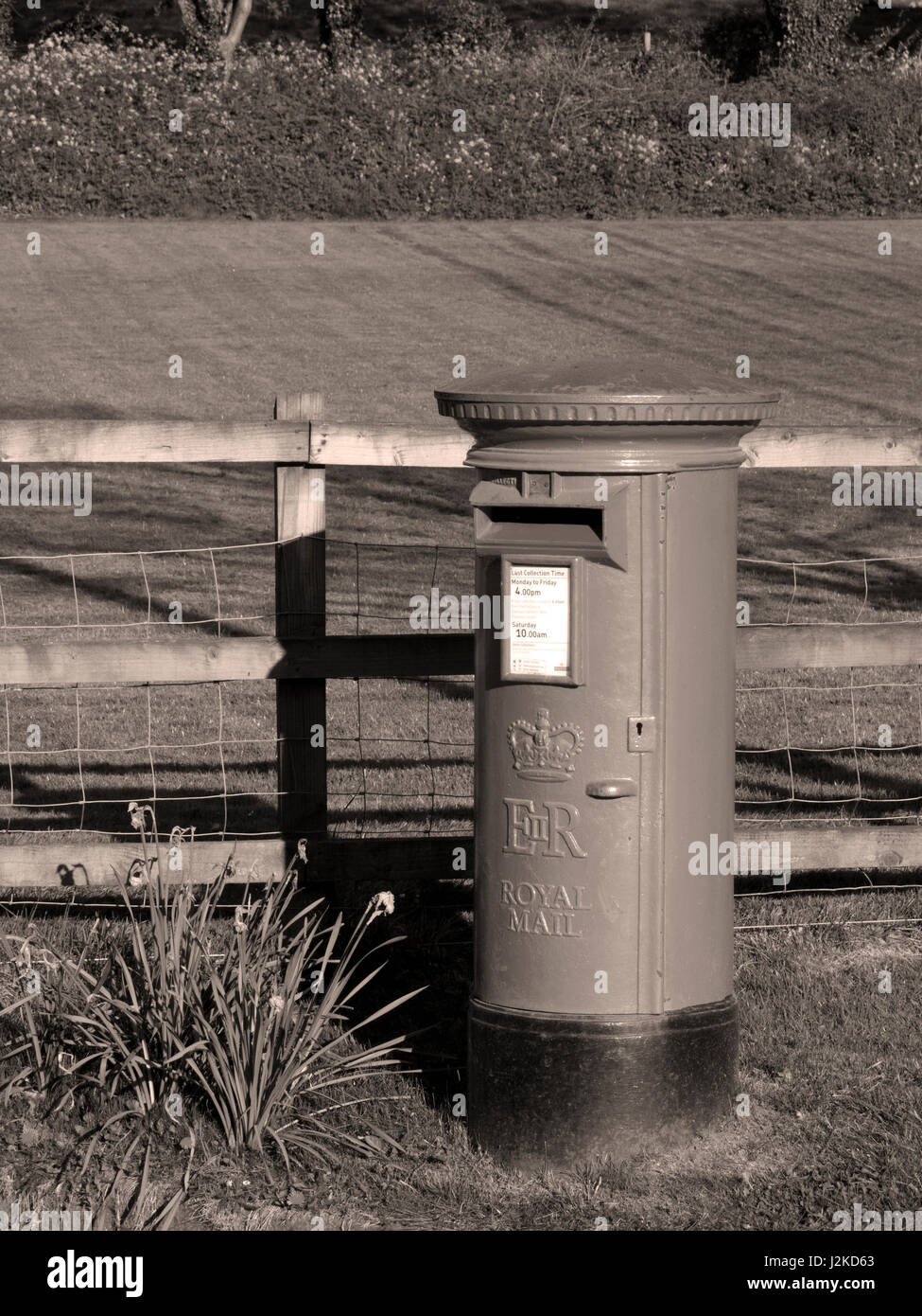 Sepia Royal Mail postbox in countryside rural setting with village ...