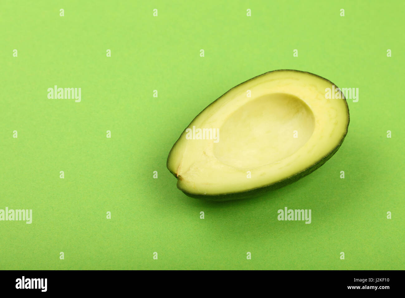 One fresh ripe avocado (Persea gratissima) half without pit stone on ...