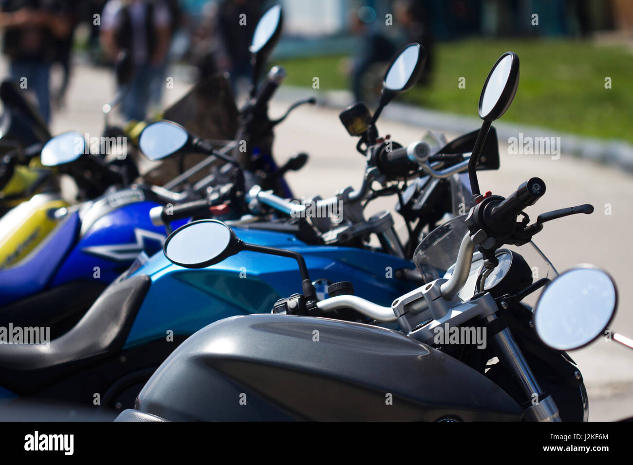 vertical detail row of parked motorcycles in the street selective focus ...