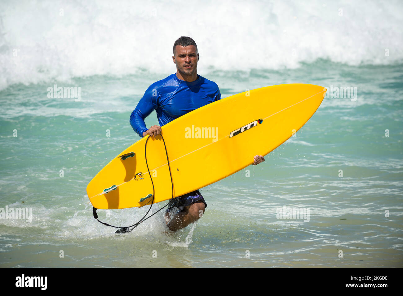 RIO DE JANEIRO - FEBRUARY 9, 2017: Young Brazilian surfer carries his ...