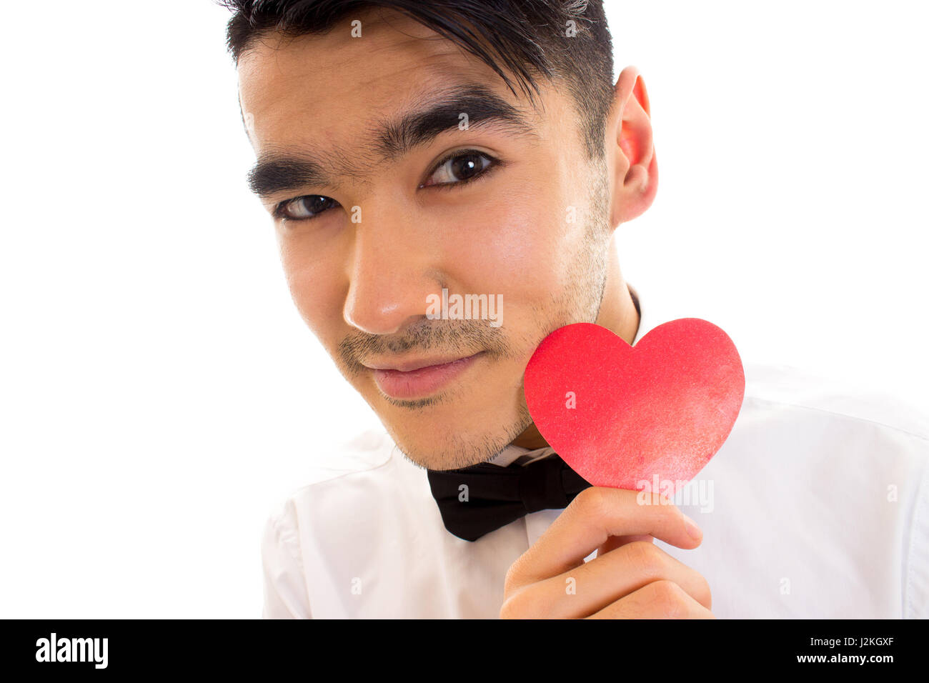 Charming young man with dark hair in white T-shirt with black bow-tie ...